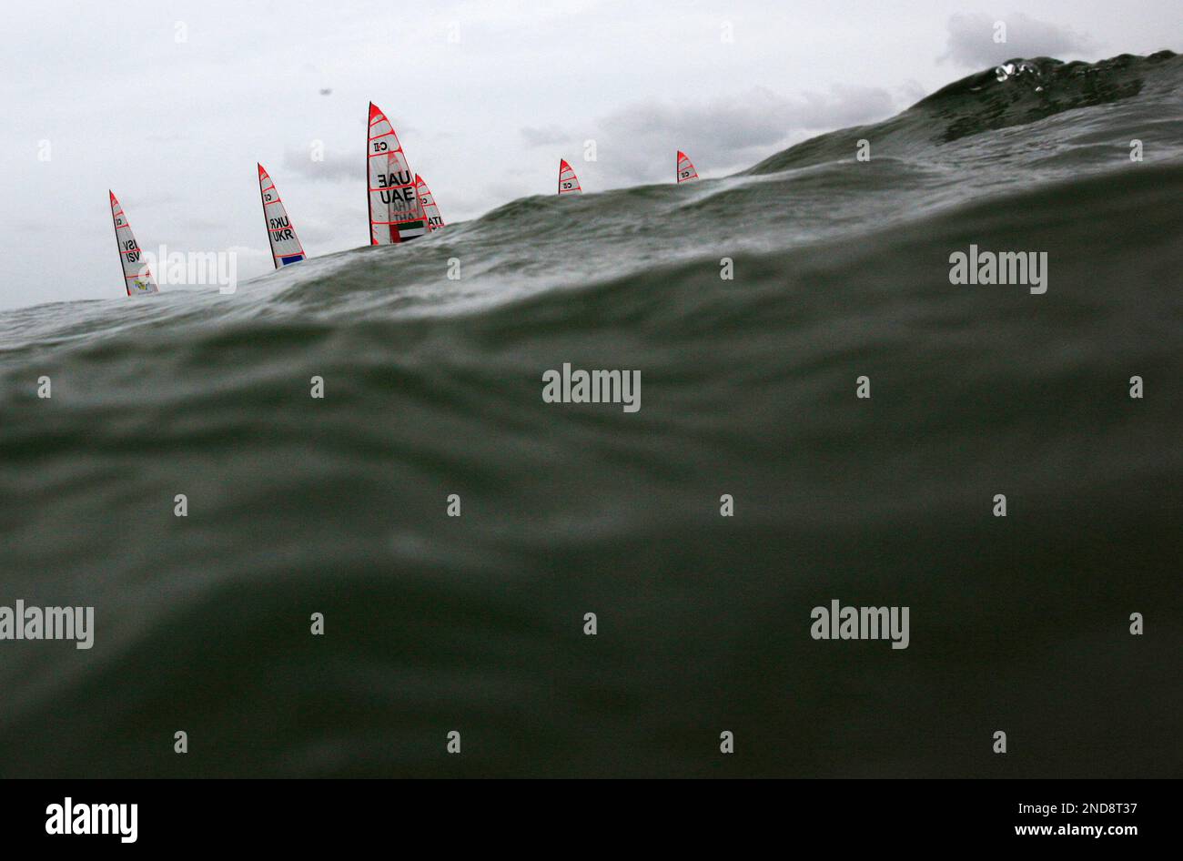 Main sails of the Boys' dinghies peak out from behind the waves during ...