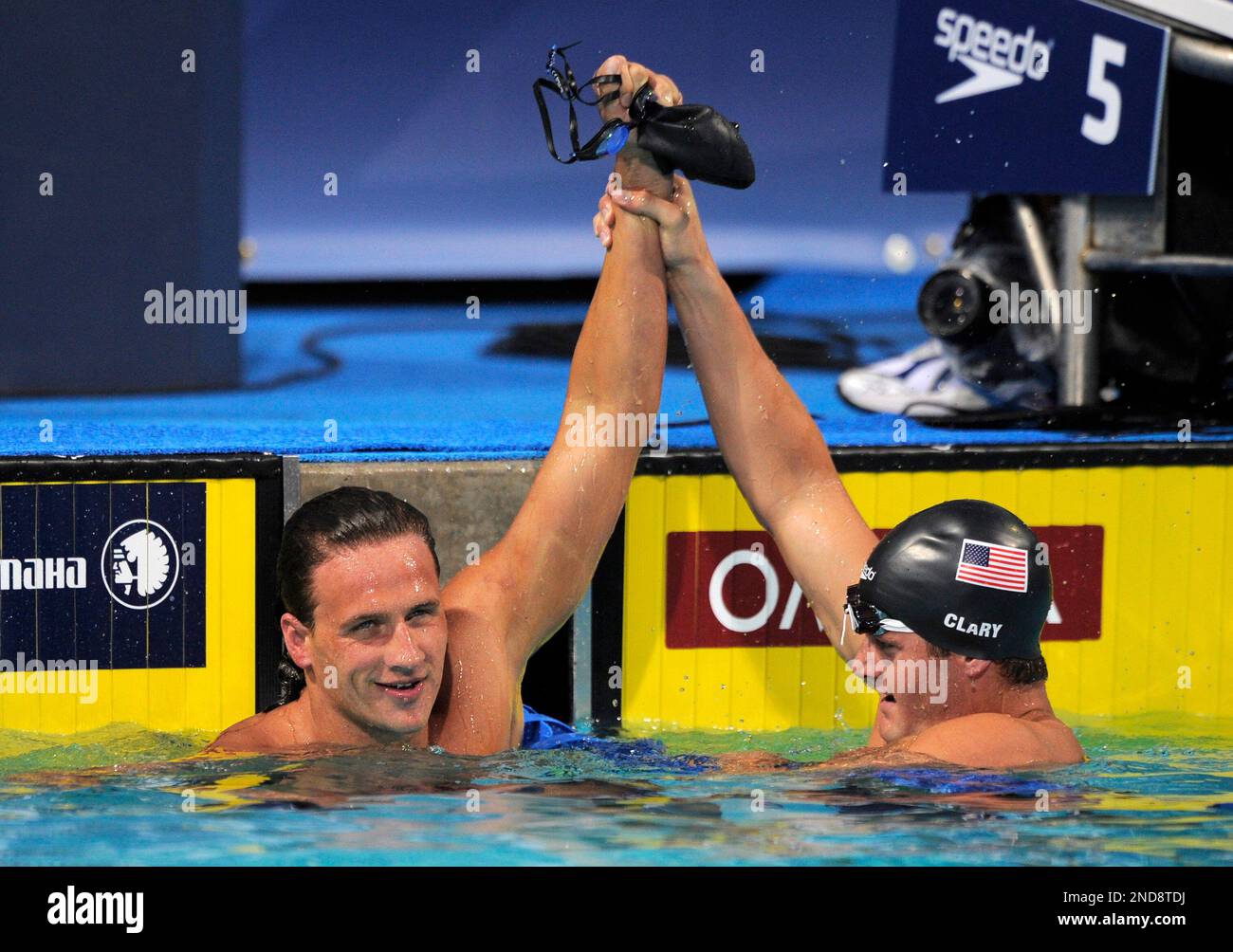 Tyler Clary, right, holds up the hand of Ryan Lochte after swimming the ...