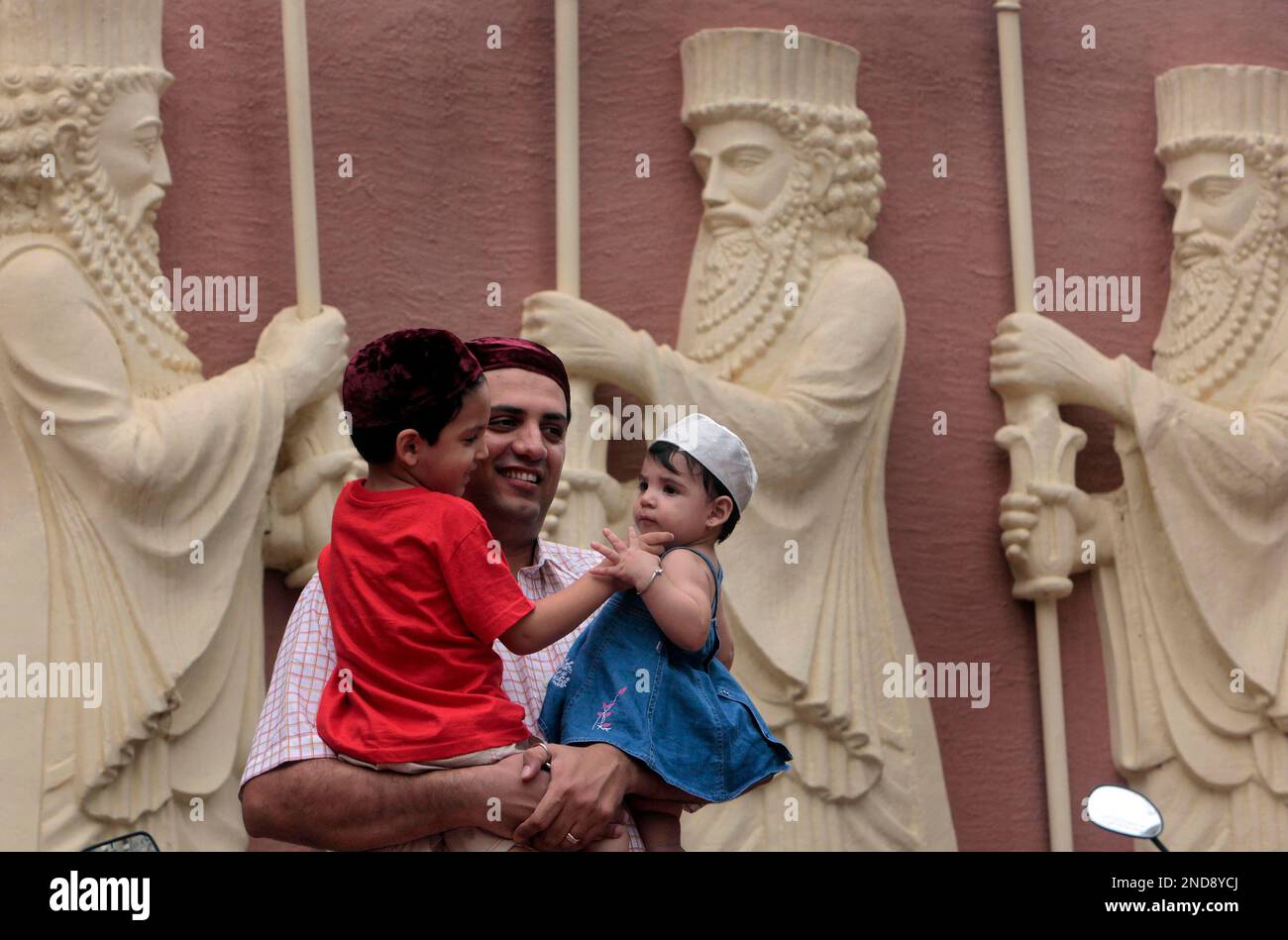 A man holding his children comes out of Parsi fire temple featuring ...