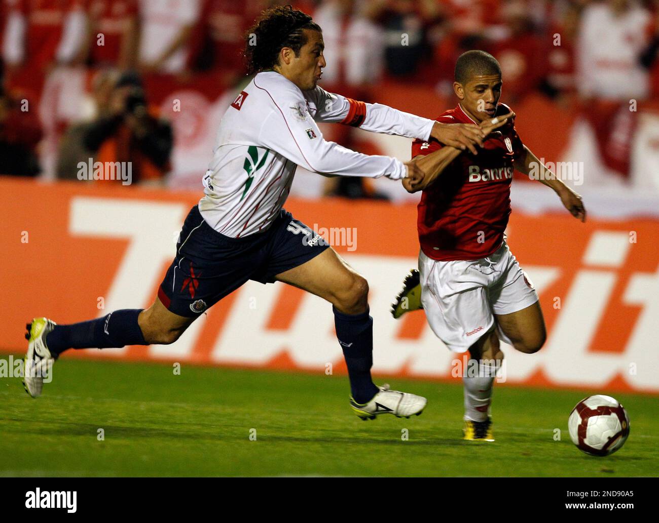 Mexico's Chivas' Hector Reynoso, left, fights for the ball with Brazil ...