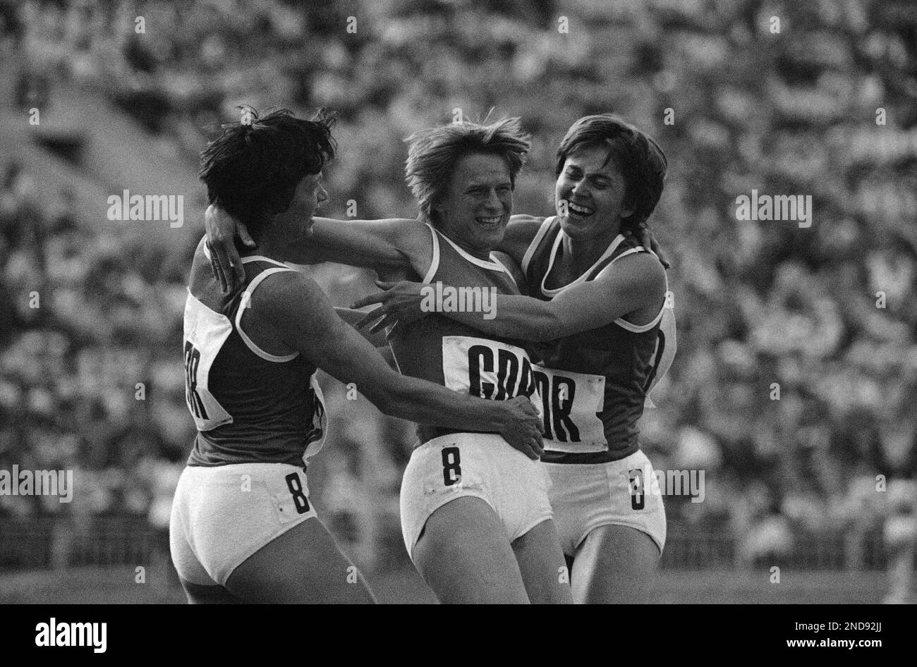 Three members of East Germany’s 4x100 relay team hug each other after ...