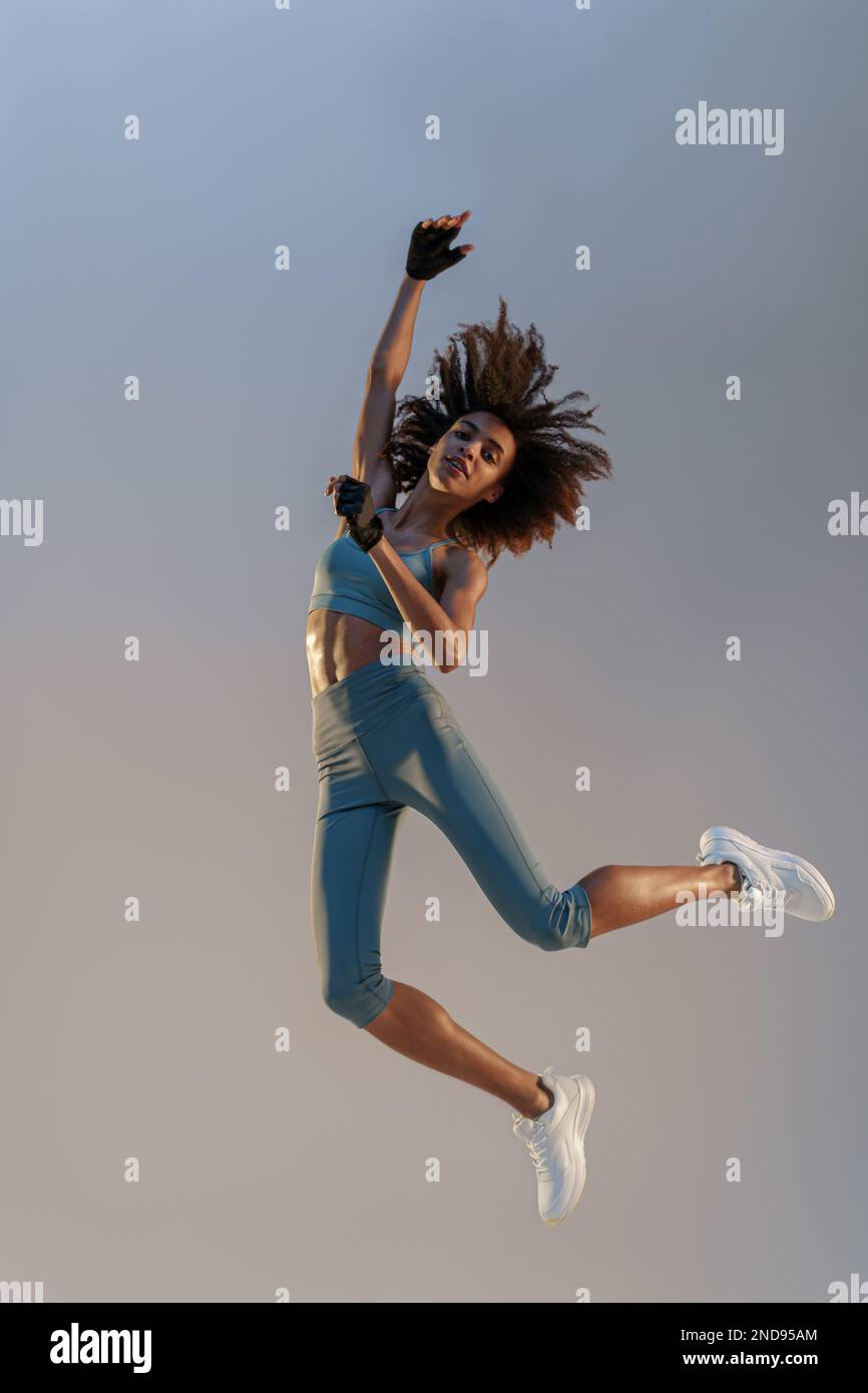 Active sporty woman in sportswear jumping on studio background. Sport ...