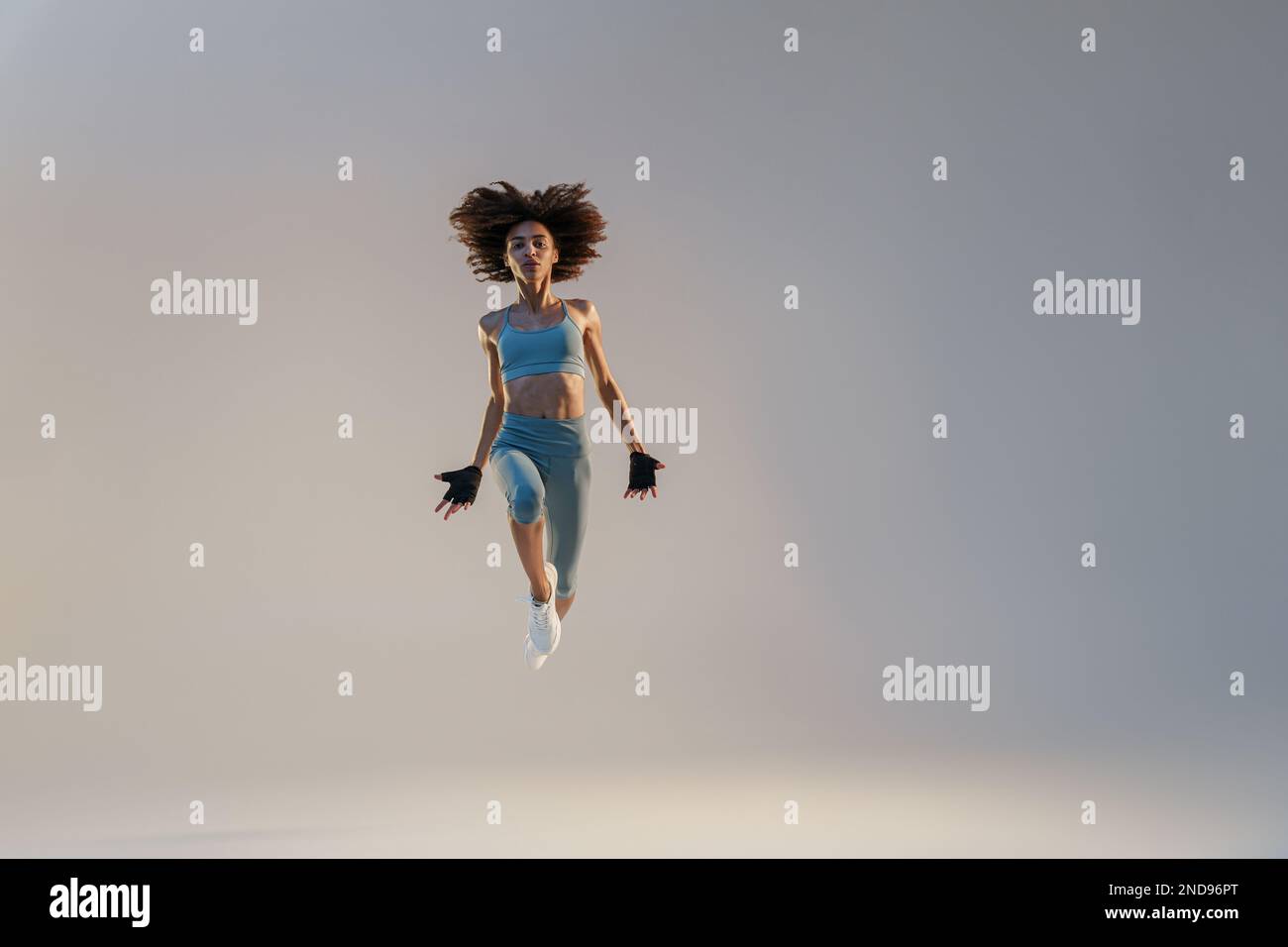 Active sporty woman in sportswear jumping on studio background. Sport ...