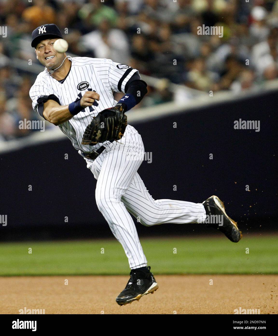 New York Yankees shortstop Derek Jeter throws to first to put out ...