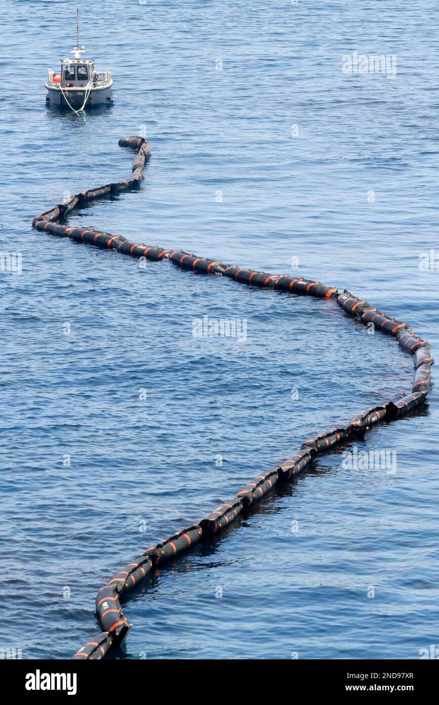 A munson boat pulls boom behind the Pacific Responder oil skimming ...
