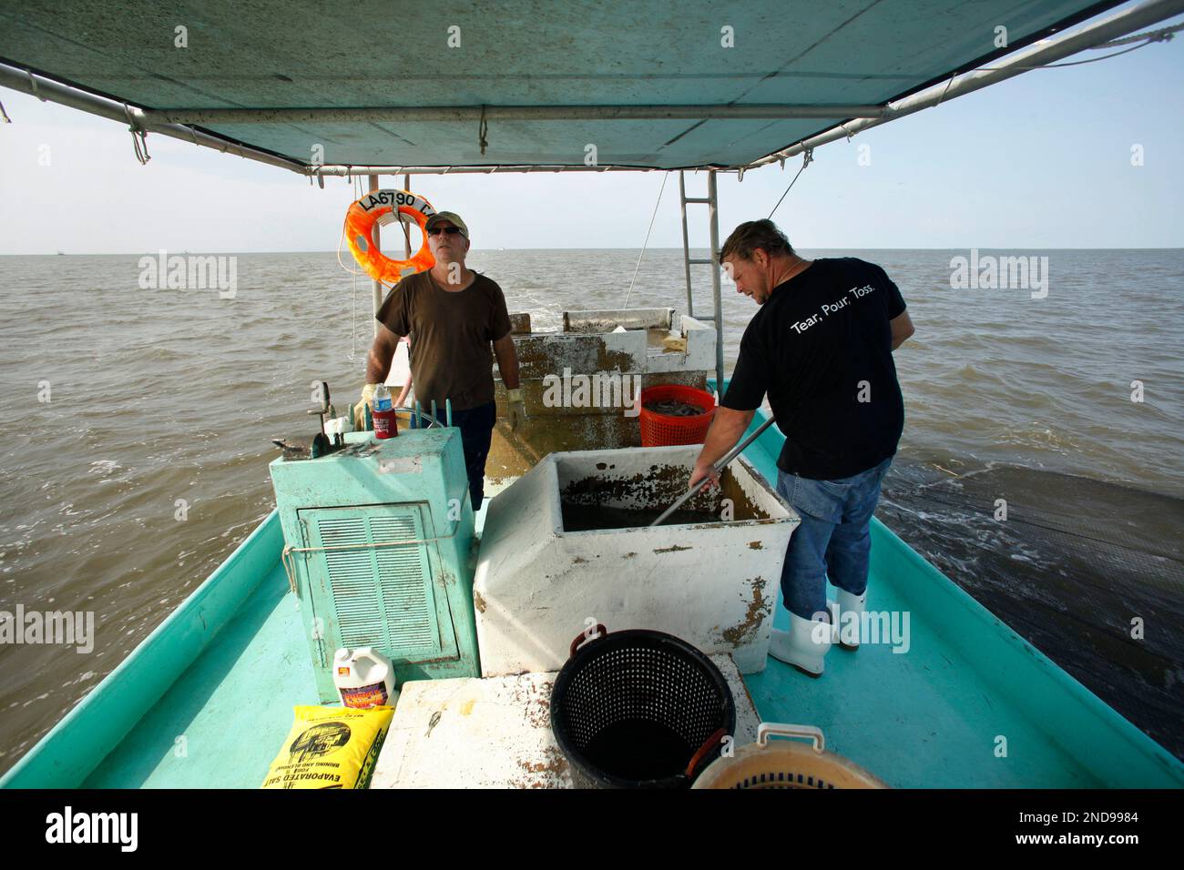 Shrimper Brian Amos left, and deckhand James Paul, right, trawl for ...