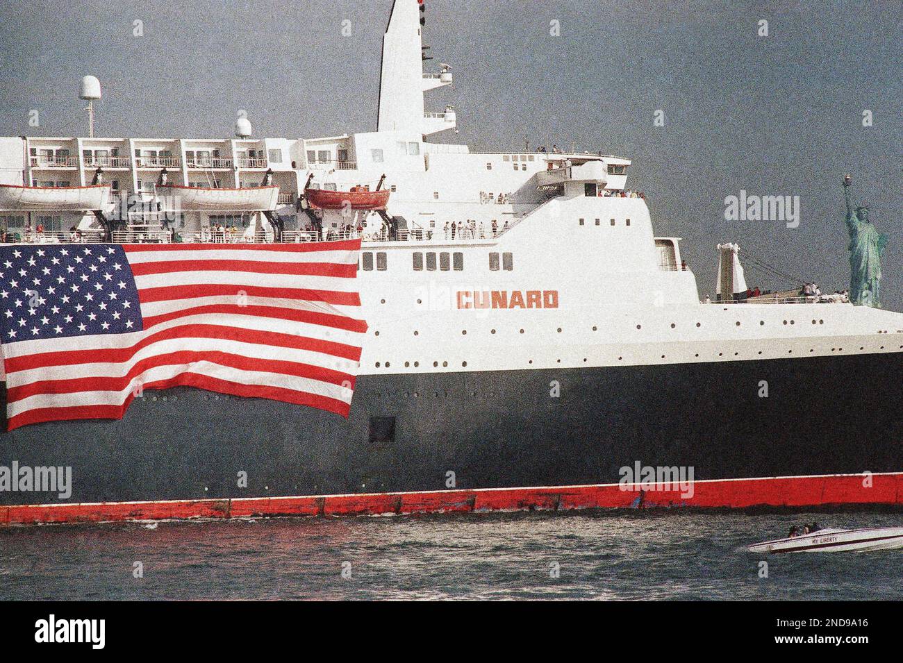 The ocean liner Queen Elizabeth II, with a large American flag draped ...