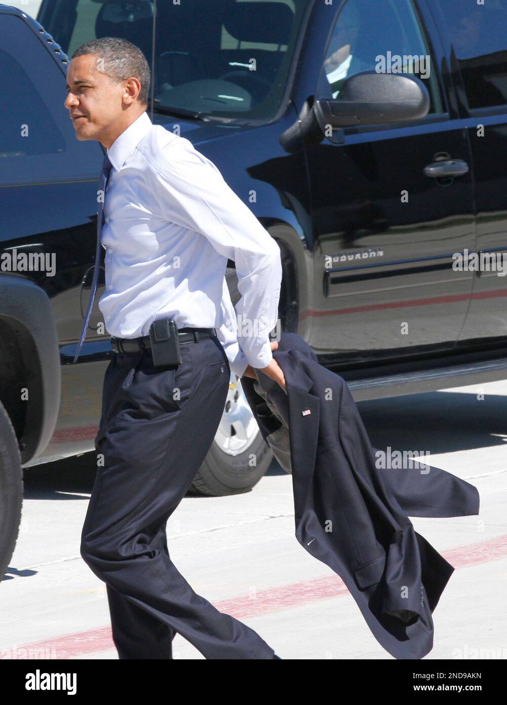 President Barack Obama takes off his jacket upon his arrival at ...