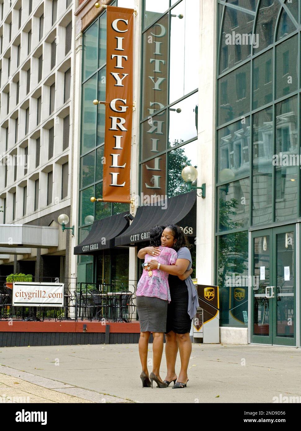 Angela Smith gets a hug from Sonya Thigpen, right, at the scene of the ...