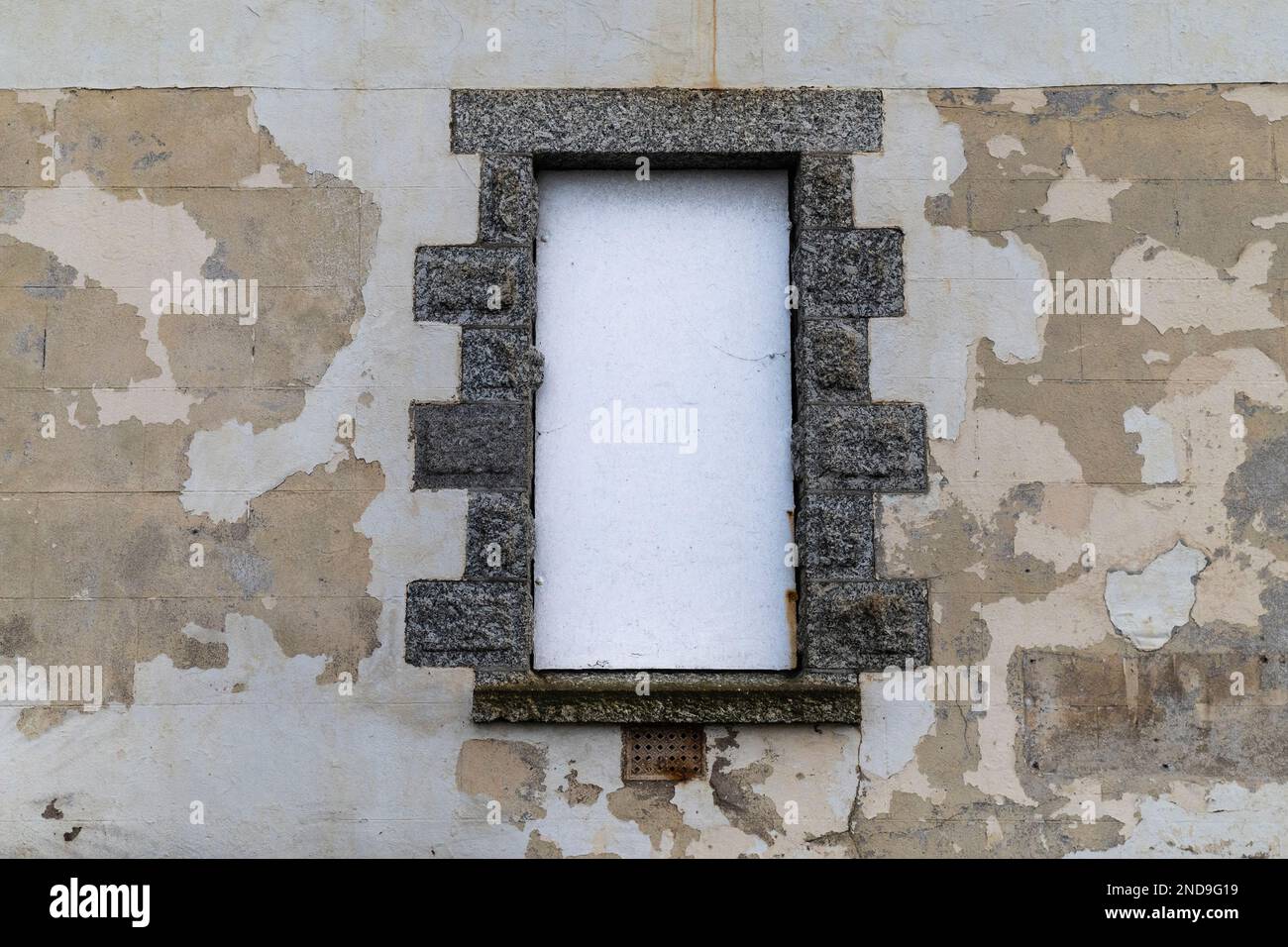 A boarded up window in a wall with peeling and flaking paint Stock ...