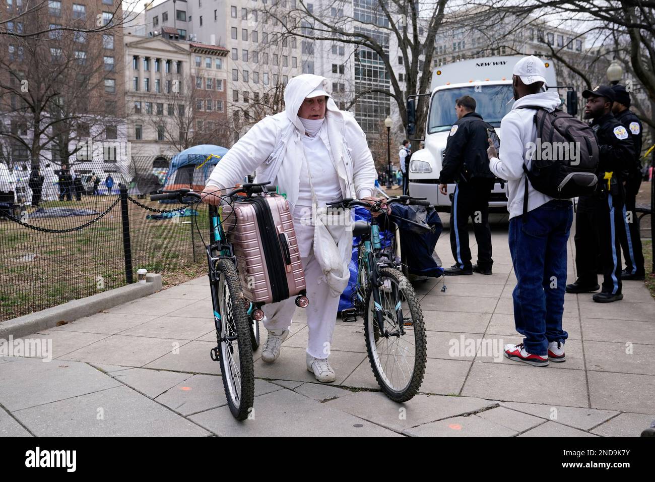 A woman carries belongings out of a homeless encampment at McPherson ...