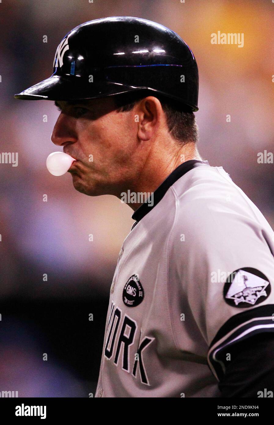 New York Yankees third base coach Rob Thomson blows a bubble during the ...