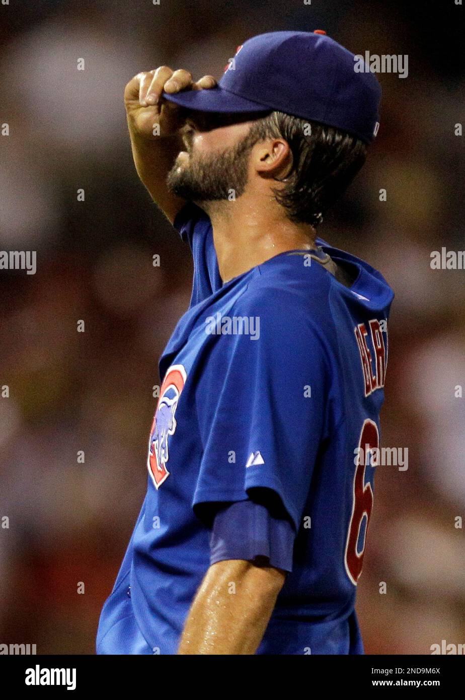Chicago Cubs relief pitcher Justin Berg adjusts his cap after giving up ...