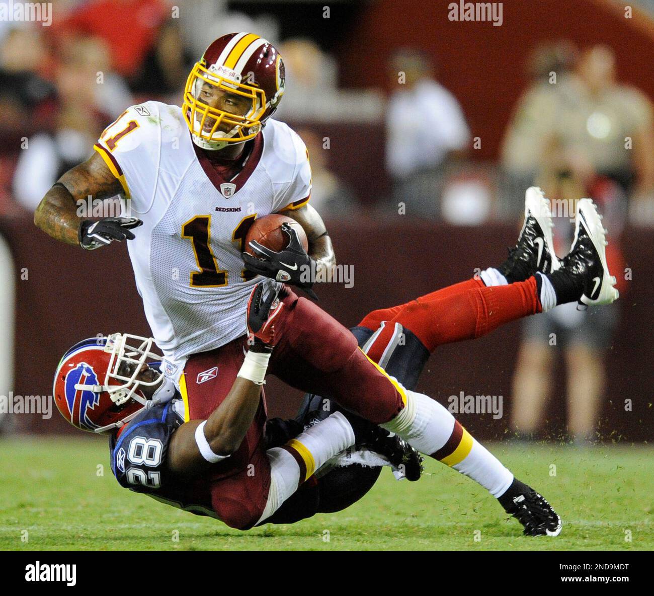 Washington Redskins wide receiver Devin Thomas is pulled down by ...