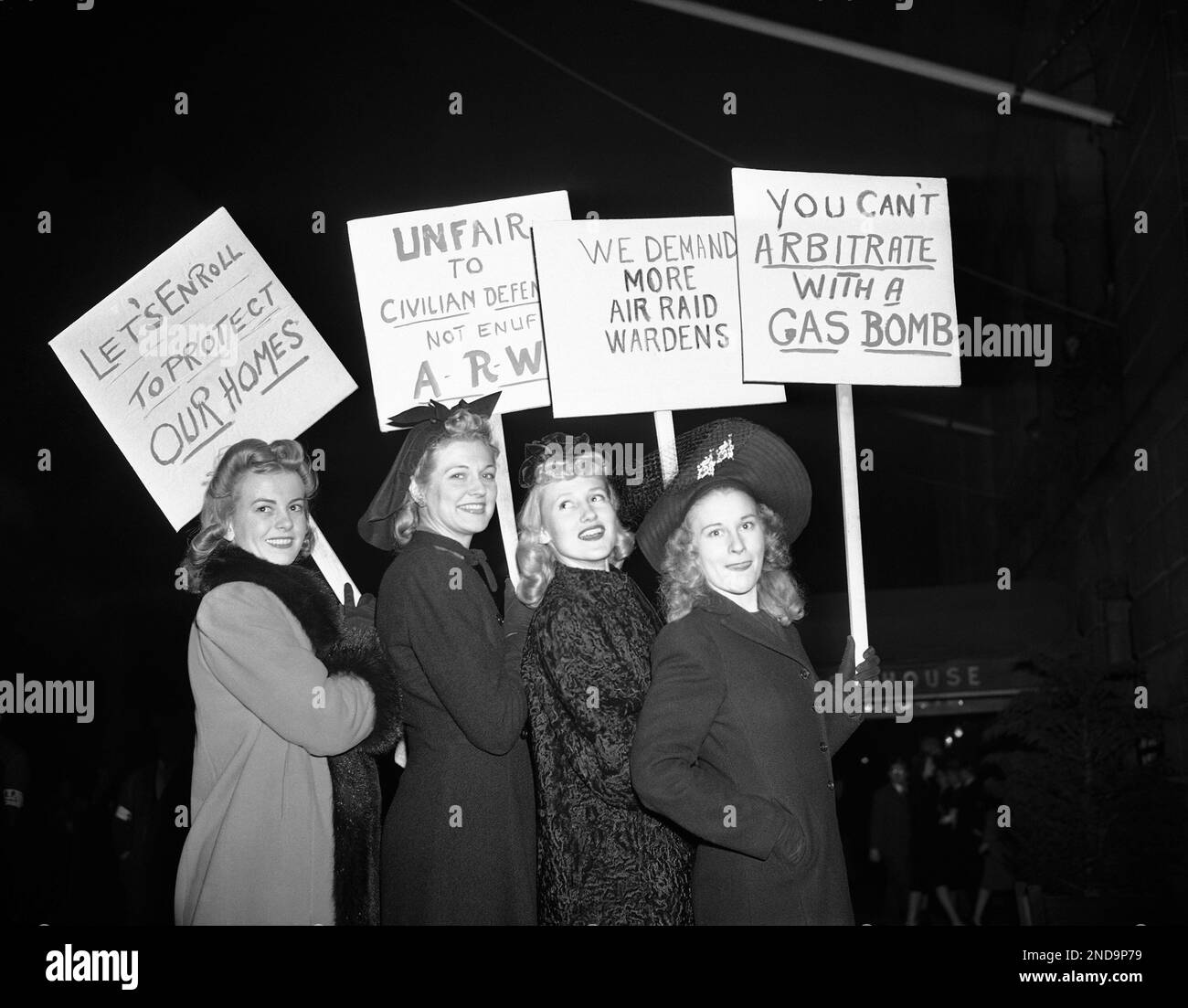 Four pretty models carry signs at a New York Air Raid warden demonstration Nov. 17, 1941 calling ...