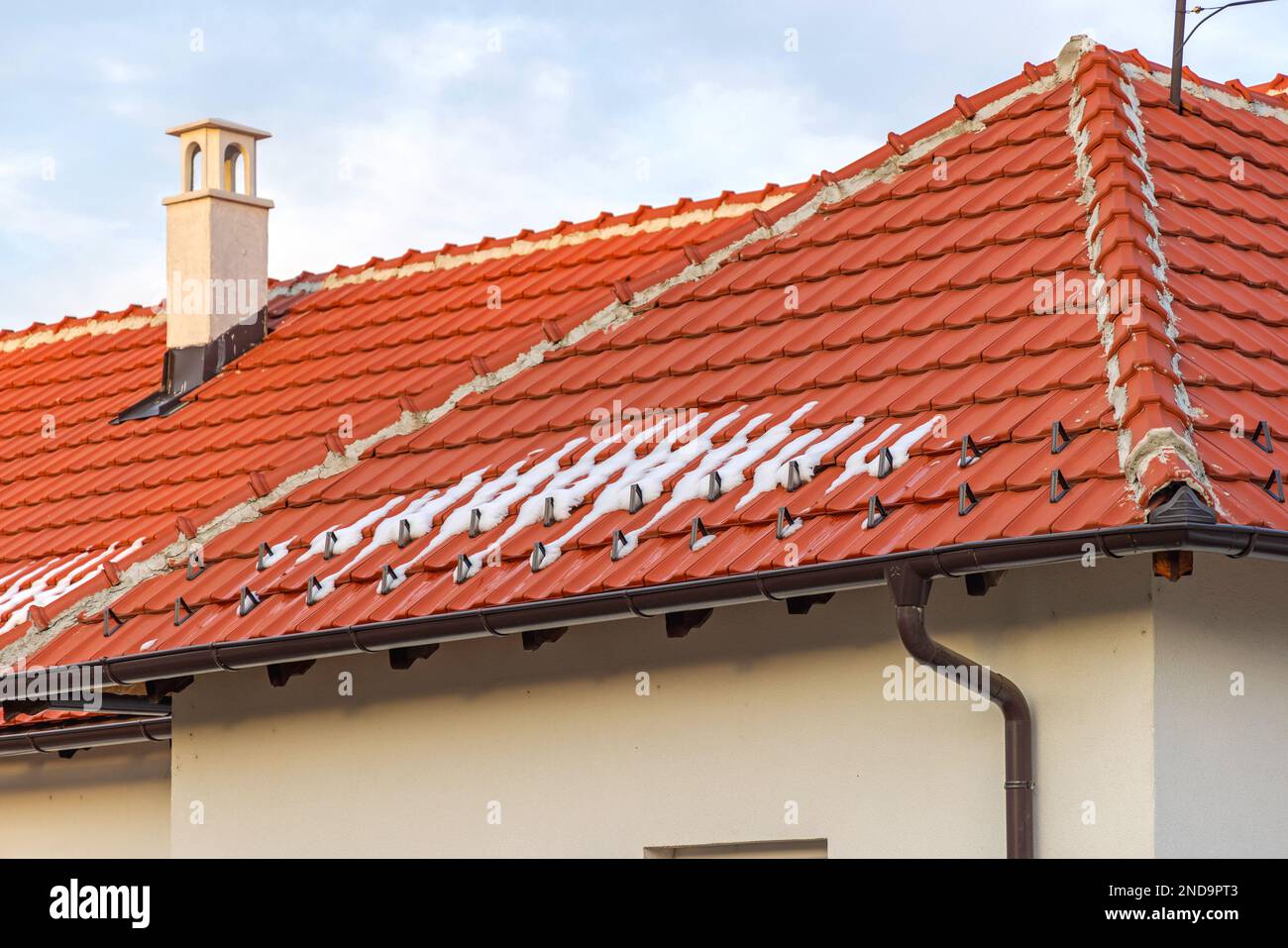 Snow Guards at Orange Ceramics Tiles Roof House Safety Stock Photo - Alamy