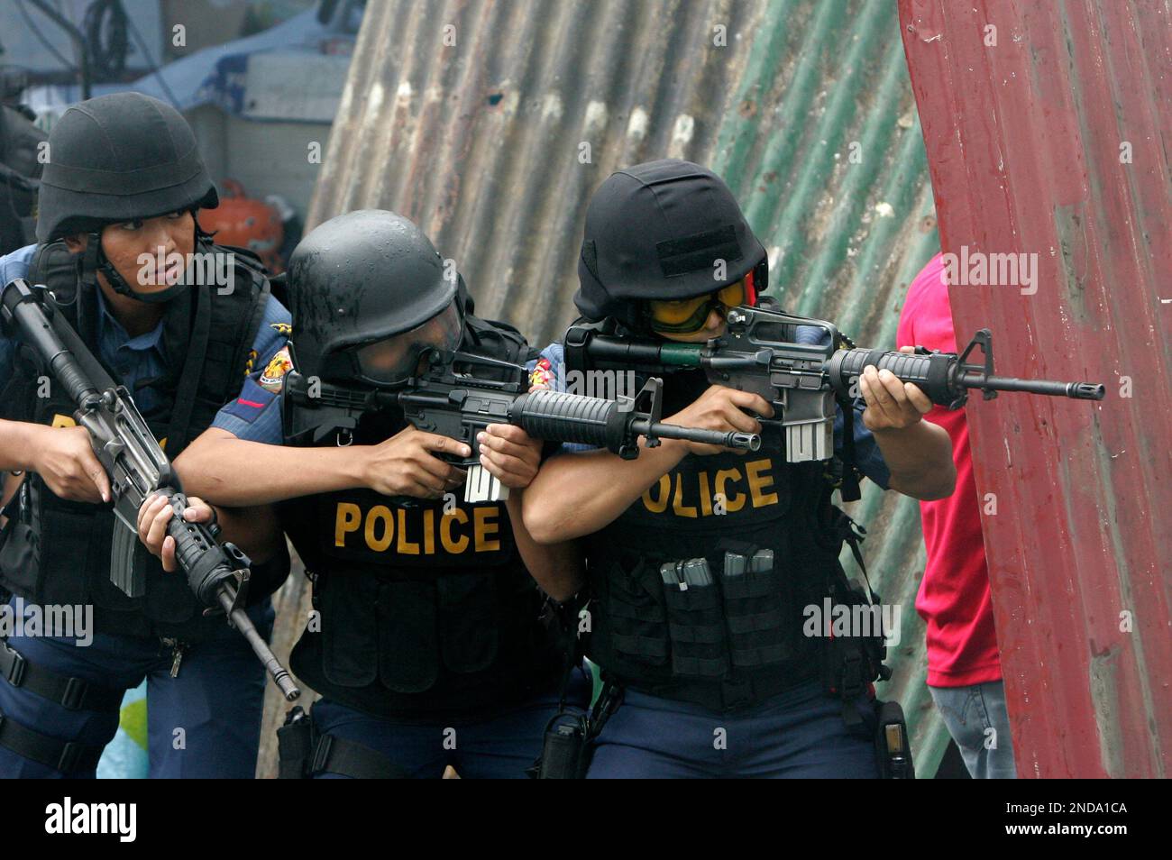 Philippine National Police SWAT members aim their rifles as they break ...