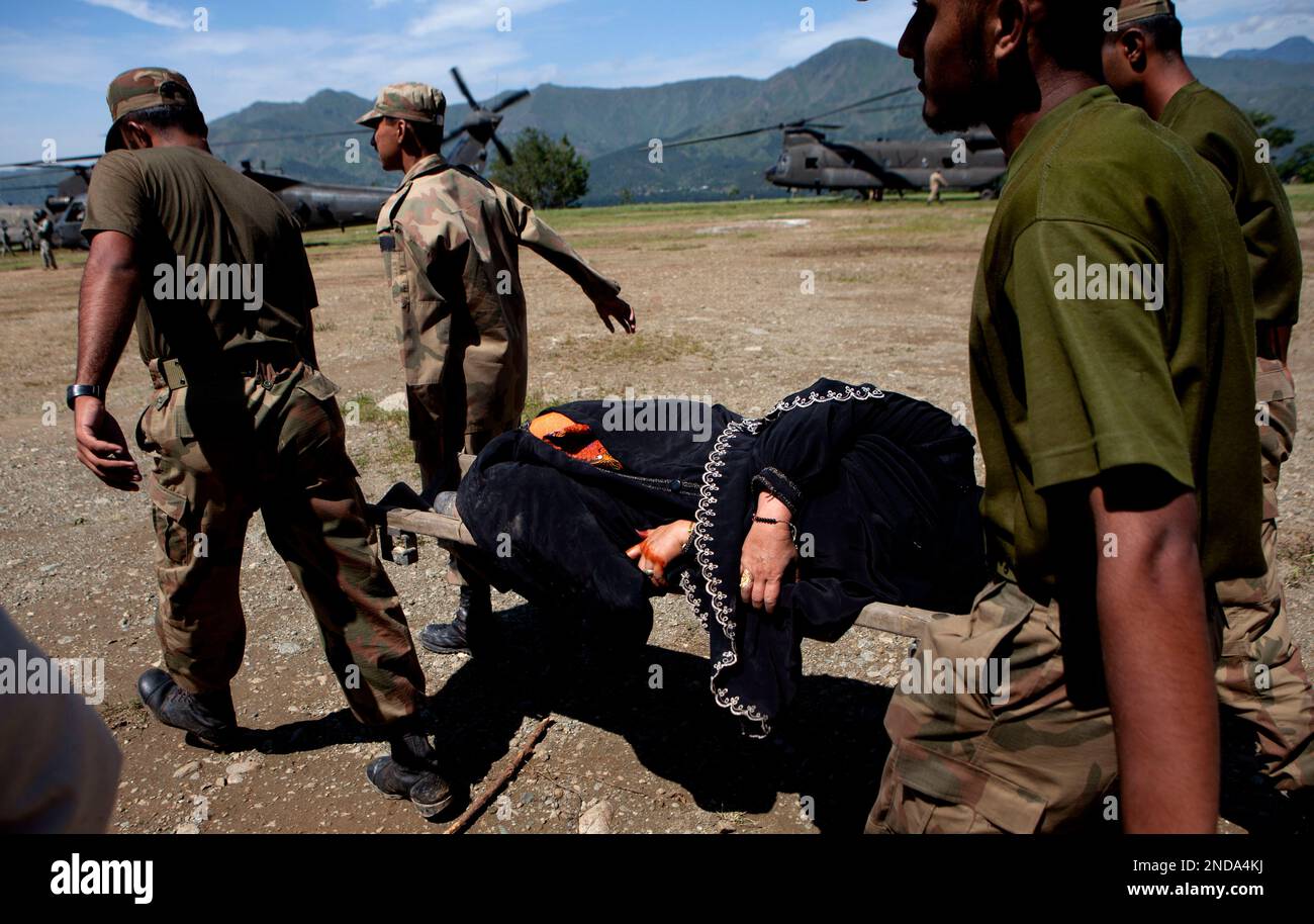 Pakistani soldiers carry an ailing woman evacuated from Kalam by the U ...