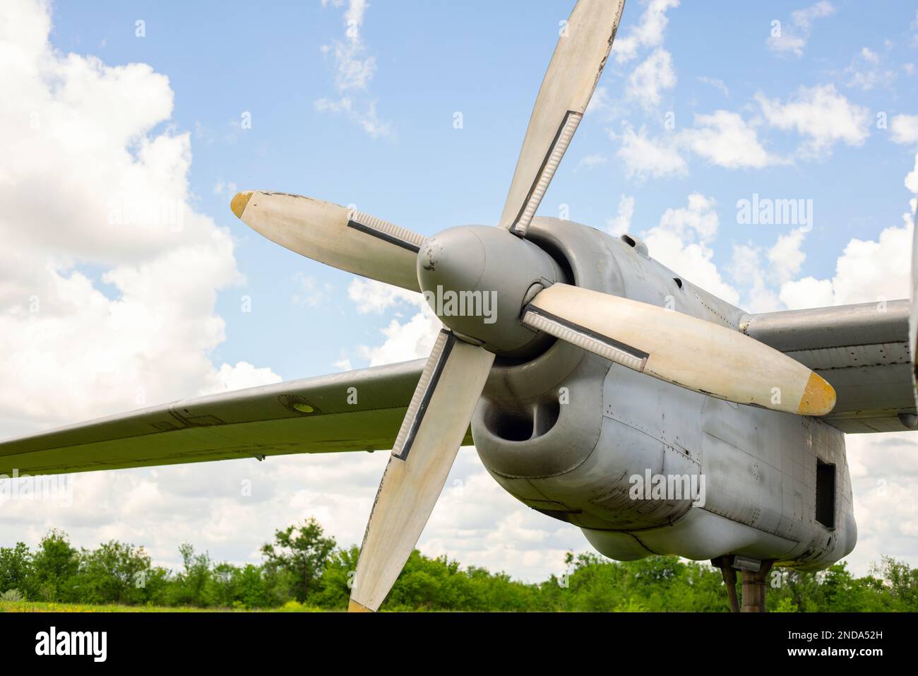 A fragment of airplane wing with four-bladed aircraft propeller against ...