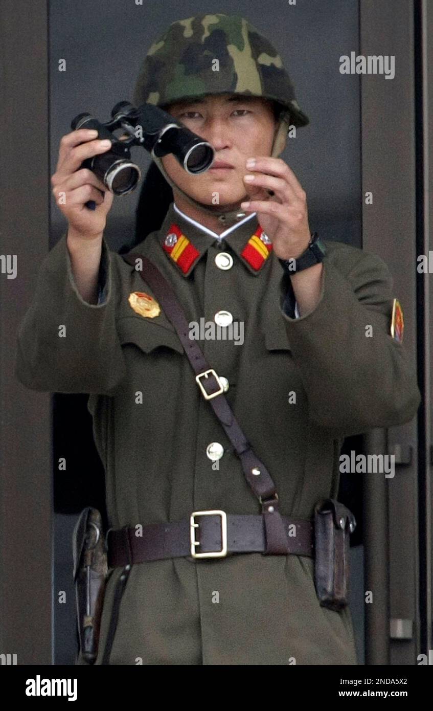 A North Korean soldier with binoculars looks at the southern side at ...