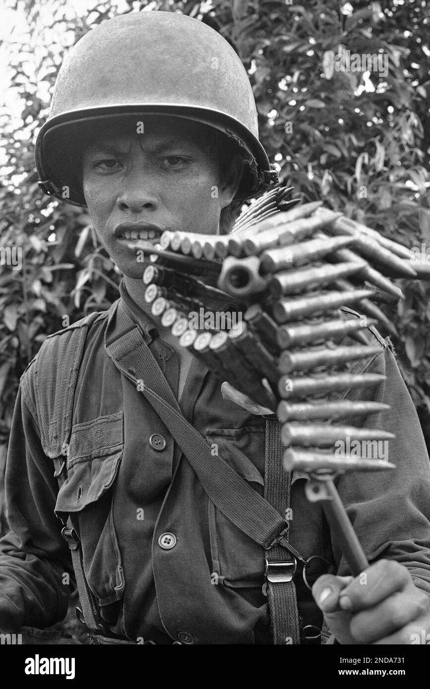 A soldier of the South Vietnamese army carries a bandolier of heavy ...