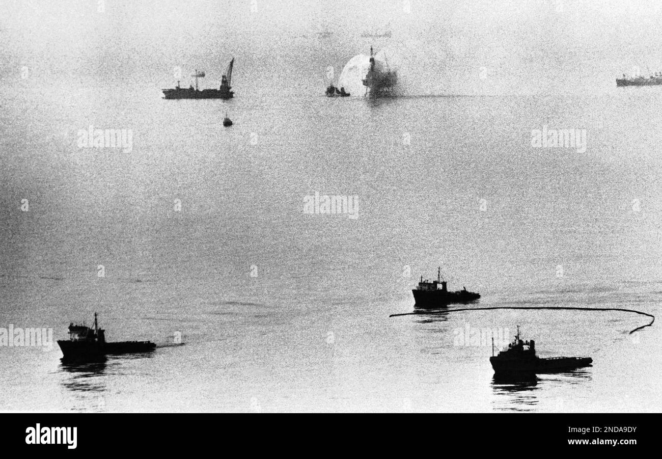 Small boats extend a boom in an effort to collect some of oil spilled ...