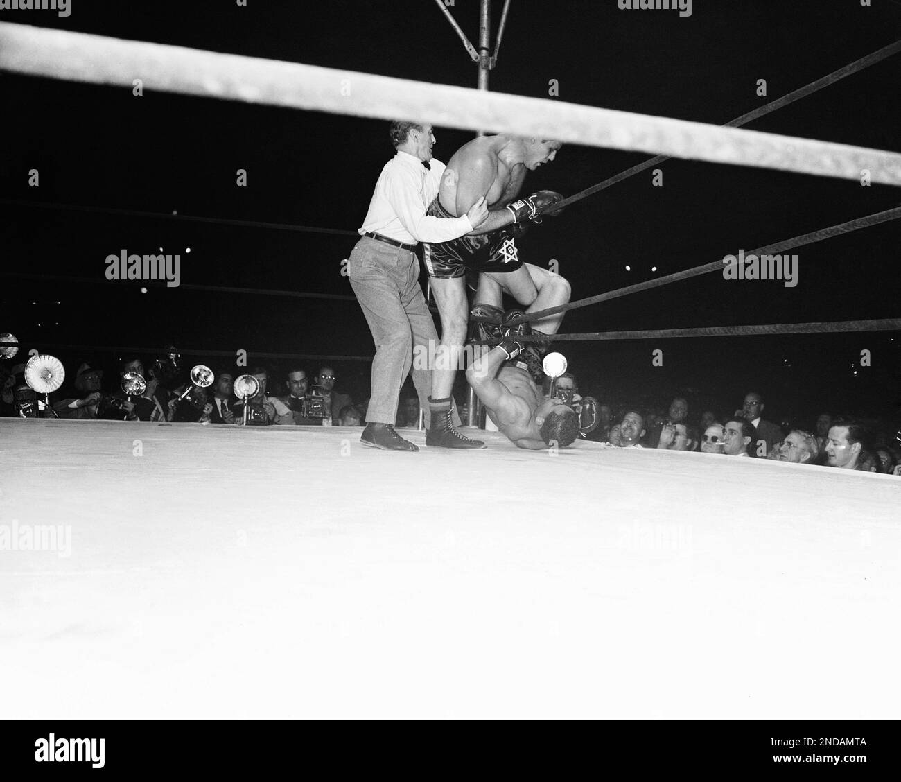Referee Arthur Donovan, left, steps in to pull Buddy Baer, center, away ...