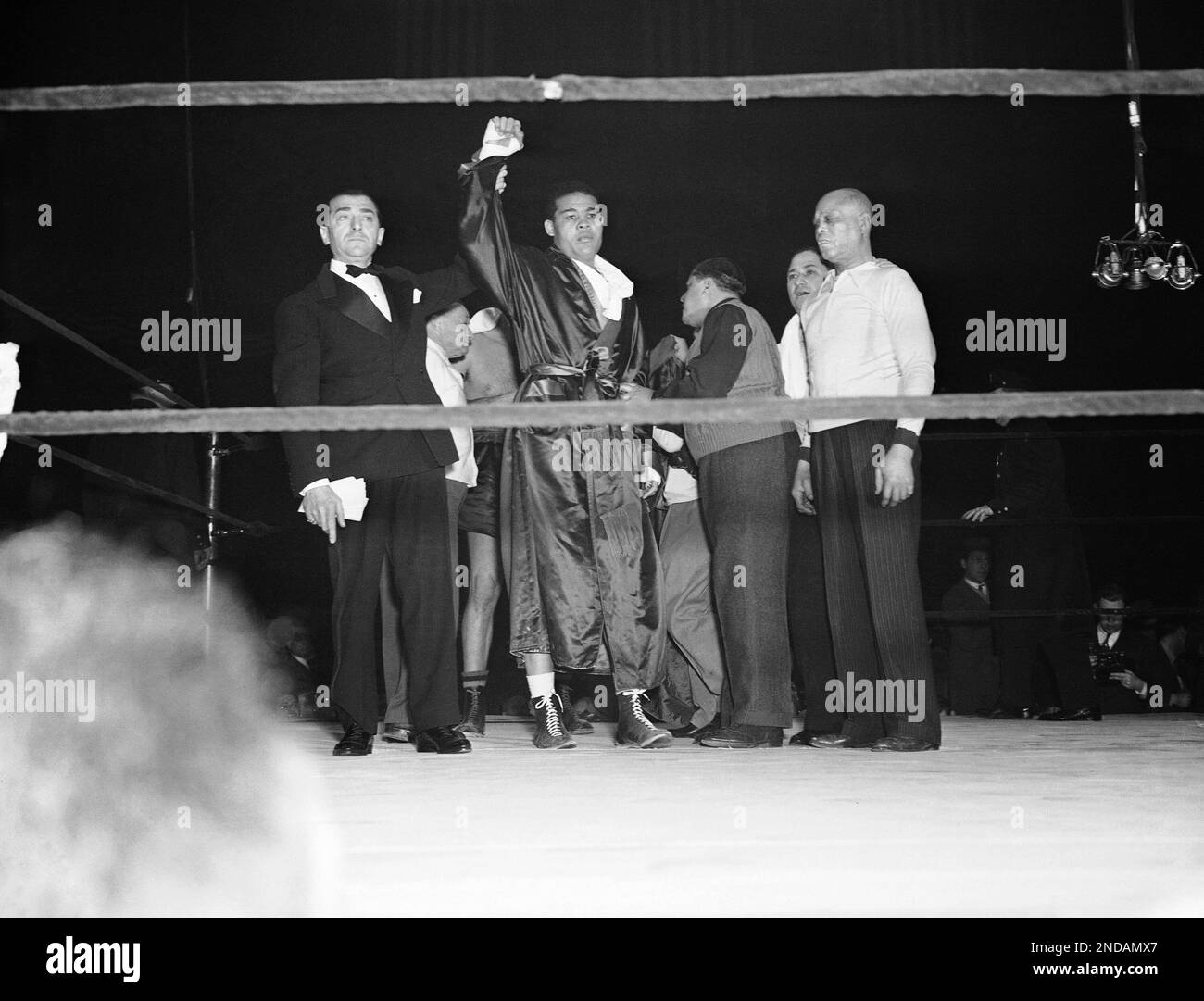 Announcer Harry Balogh raises Joe Louis's arm in token of victory after ...