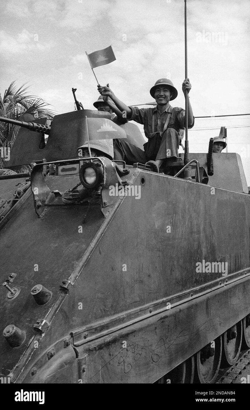 A Vietnamese soldier waves a Cambodian flag atop on armored personnel ...