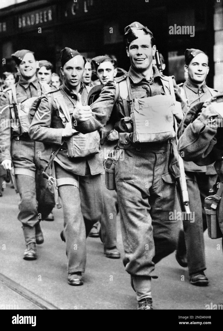 With thumbs up a song on their lips, these British troops march through ...