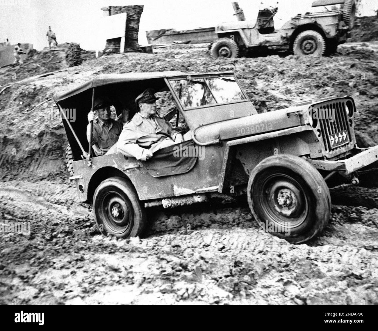 General Douglas MacArthur holds tight as his jeep bumps through the ...