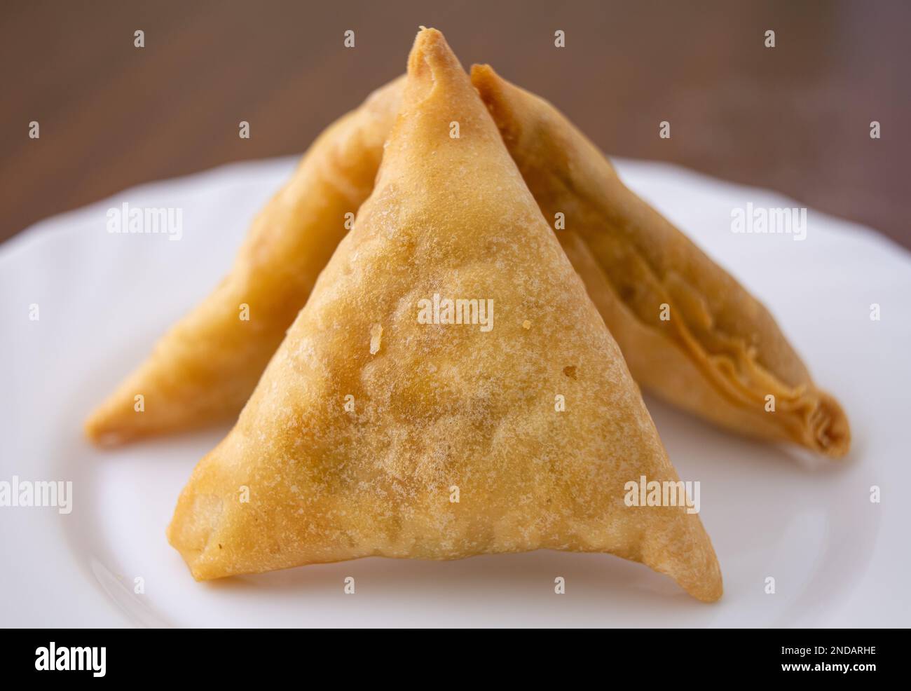 Three traingle samosas cooked at indian catering company Stock Photo ...