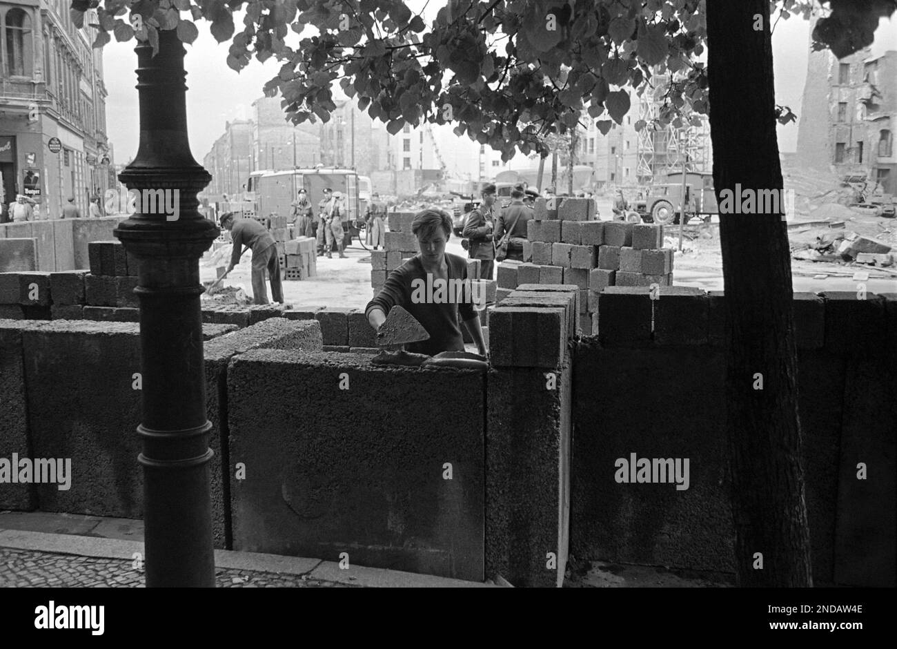 Youthful East Berliner erects concrete wall that was to be topped by ...