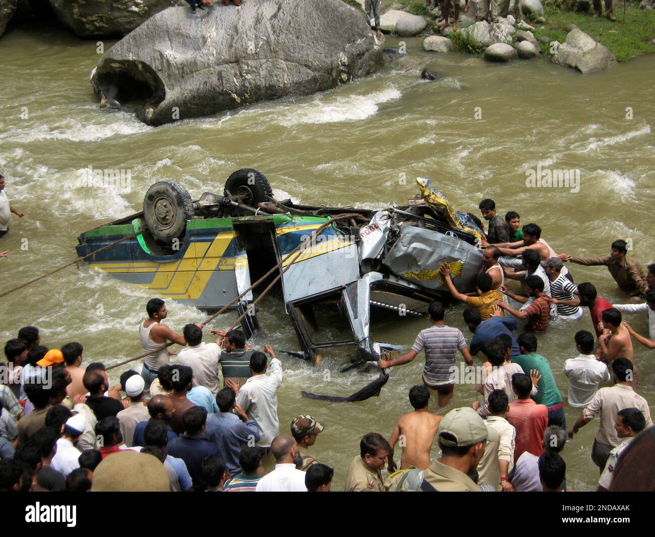 People perform rescue work after a mini bus fell into the Neeru river ...