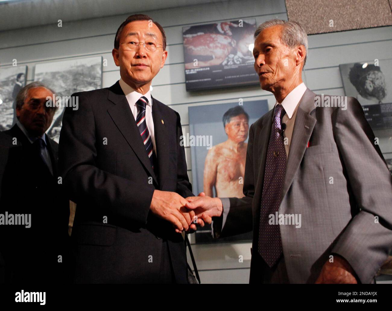 U.N. Secretary-General Ban Ki-moon, left, shakes hands with Sumiteru ...
