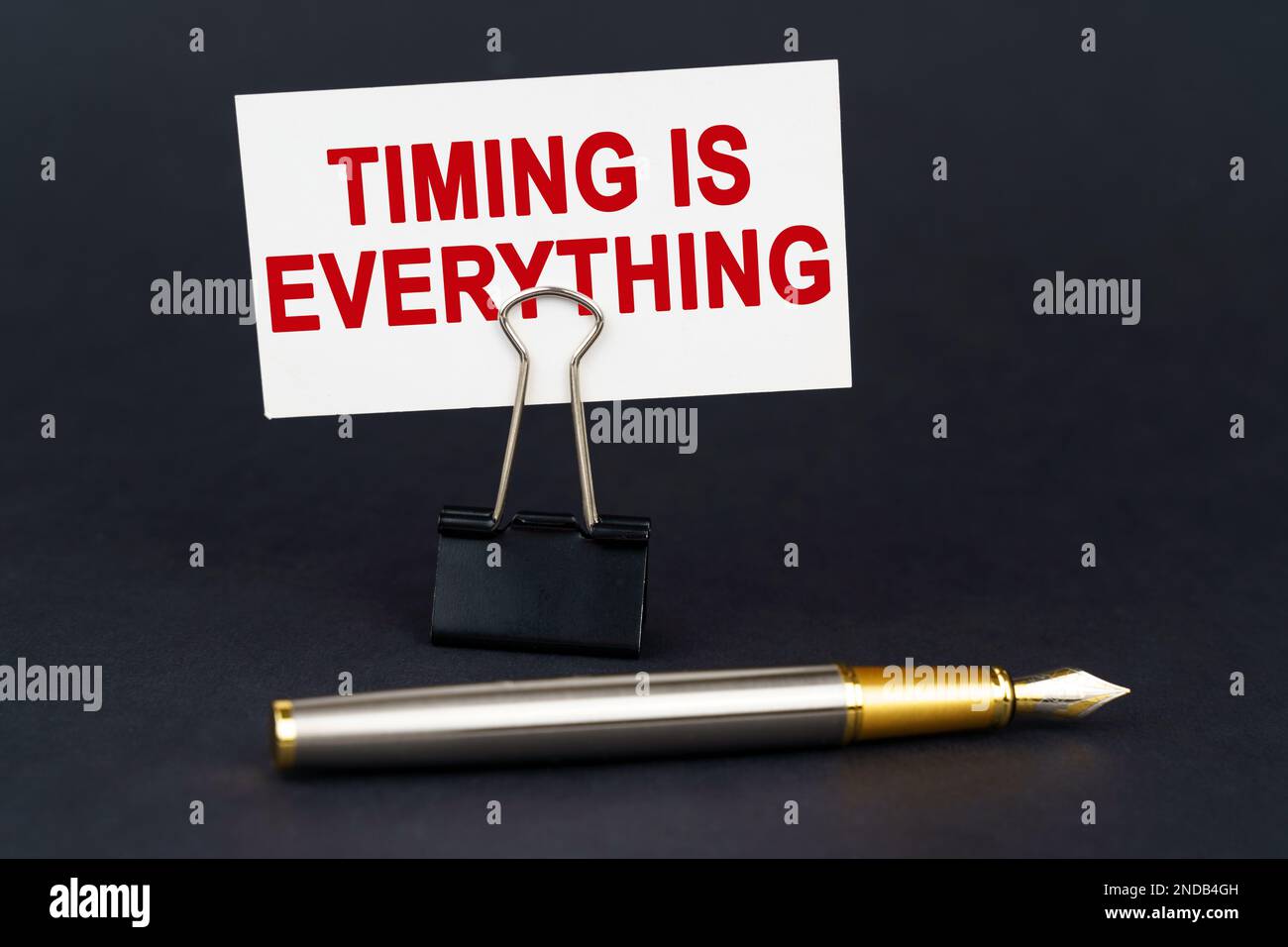 Business concept. On the black surface is a pen, an office paper clip ...