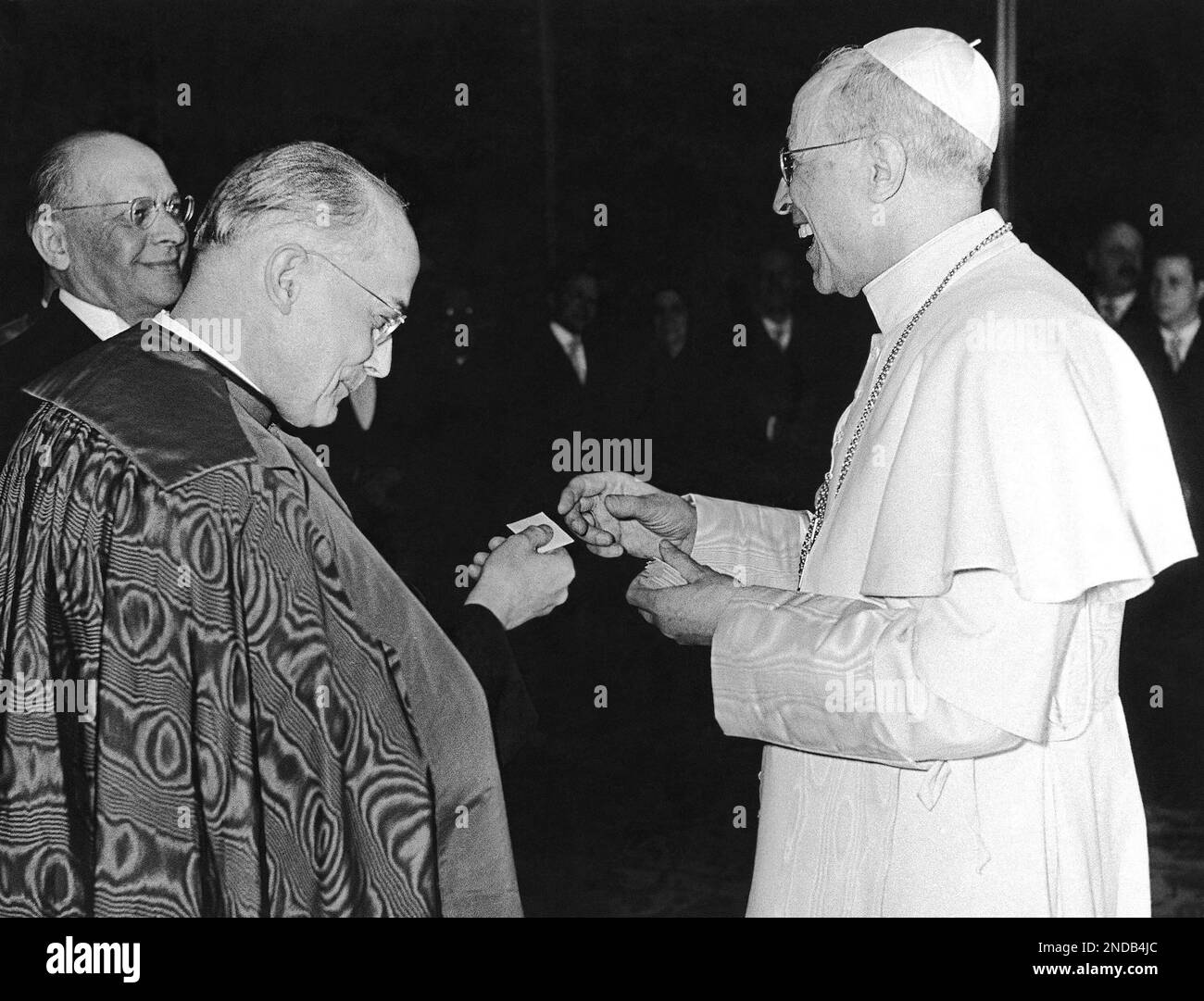 Laughing Pope Pius XII, right, shows a badge, he donated to the staff ...