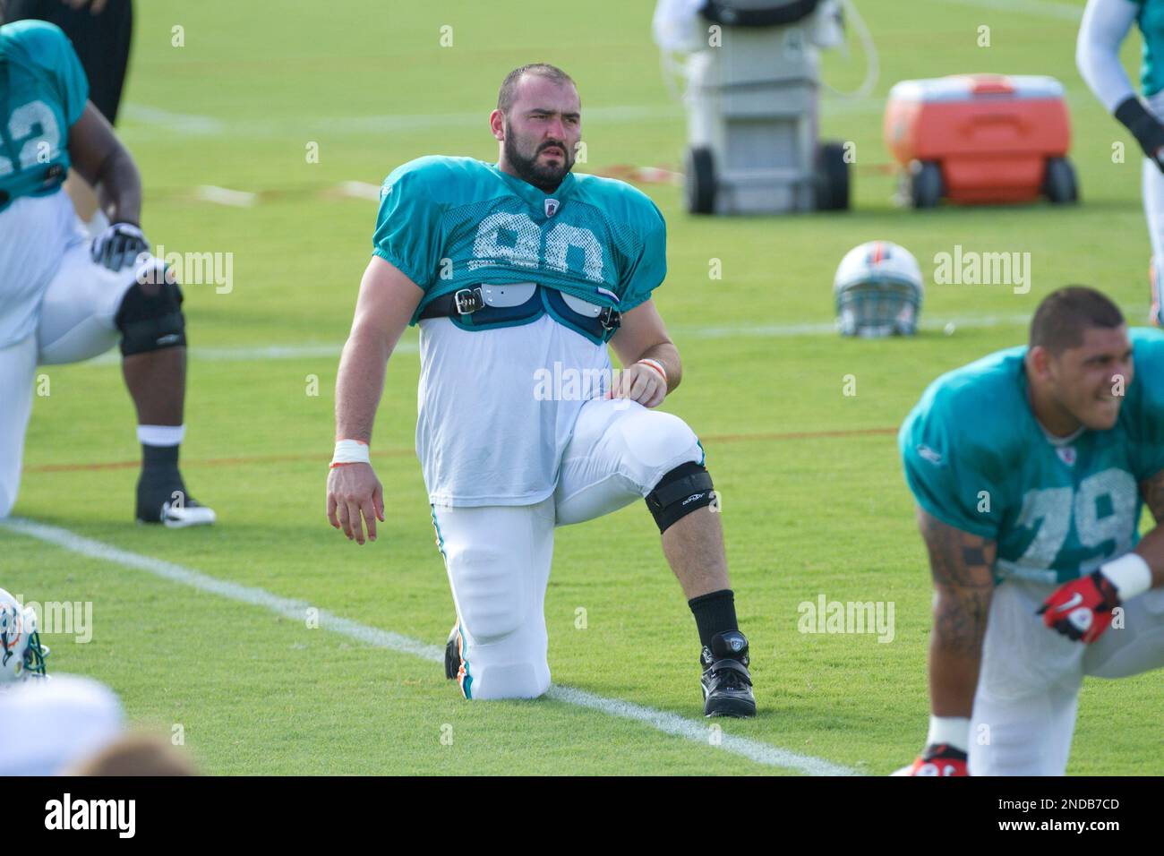 Miami Dolphins player Ryan Baker (90) stretches during morning drills at the NFL football camp ...