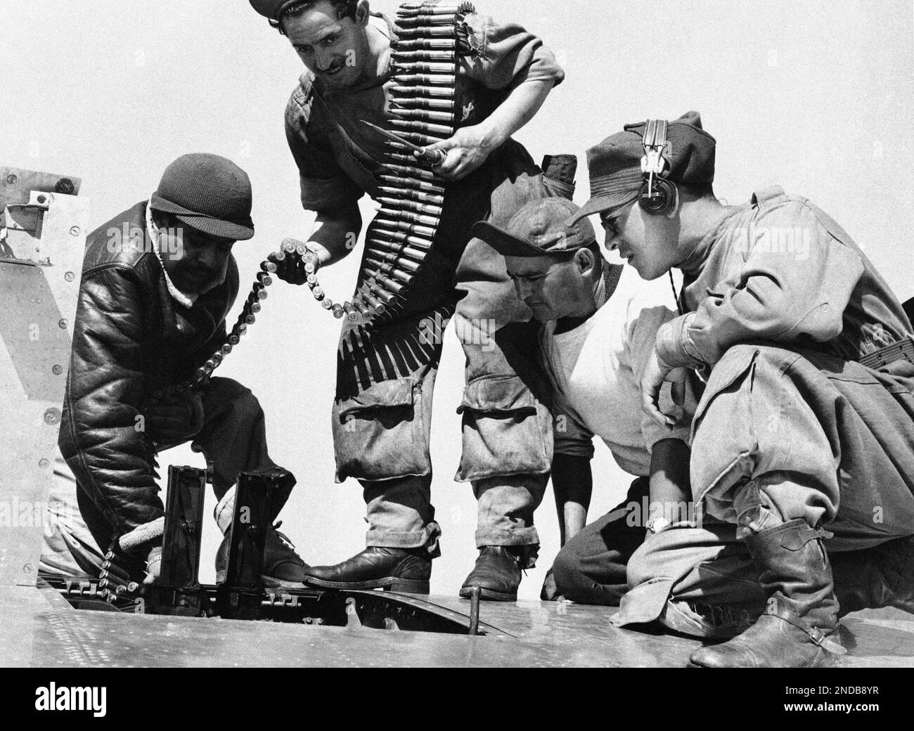 Loading a long belt of 50-dialer machine gun bullets in one of the ...