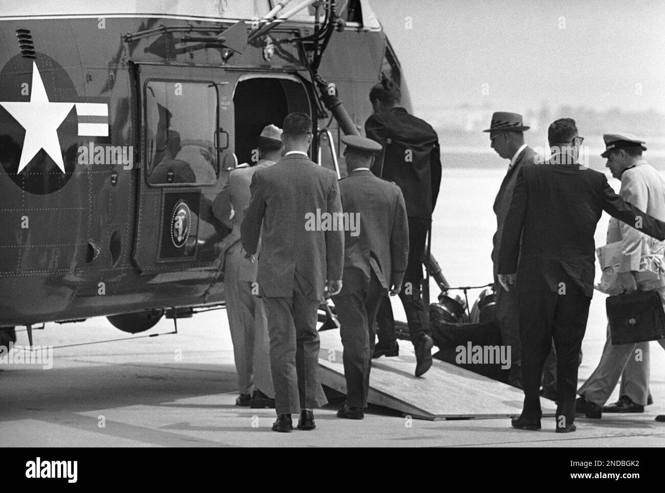 President John Kennedy, using crutches due to a back injury, goes up an ...