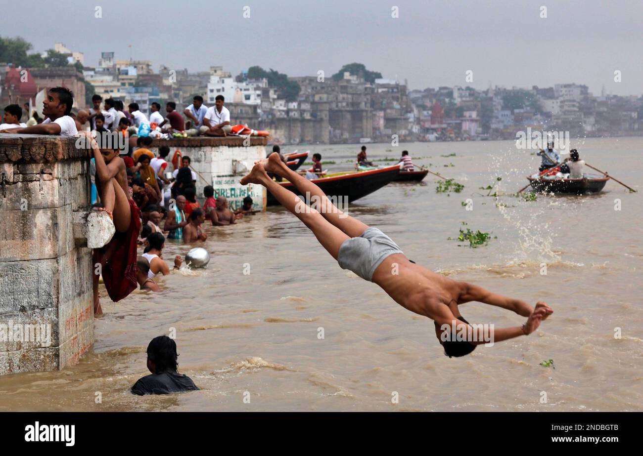 A boy dives into the River Ganges, in Varanasi, India, Monday, Aug. 2 ...
