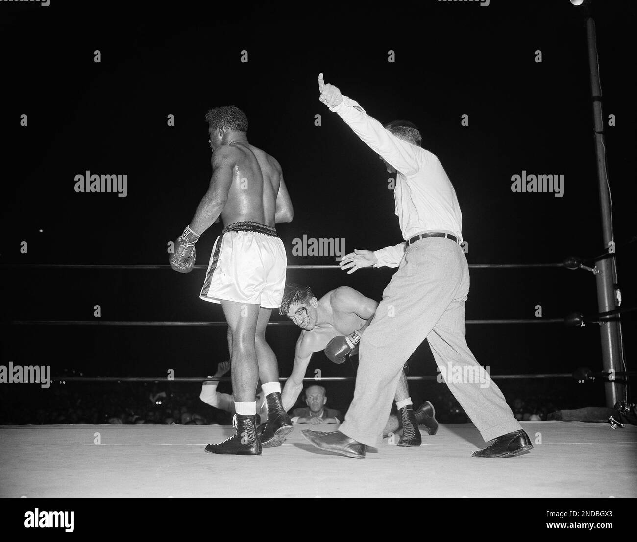 Texas’ Roy Harris, his face swollen and bloody, is down on hands and ...