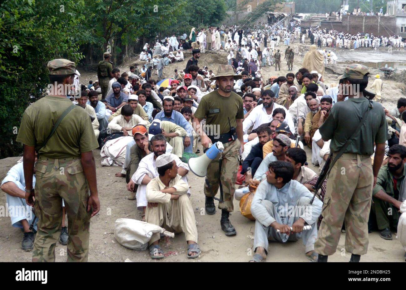 Pakistan army soldiers control flood survivors who want to go over a ...