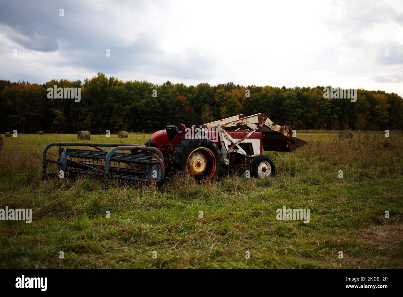 A haymaker tractor working on a field during daytime Stock Photo - Alamy