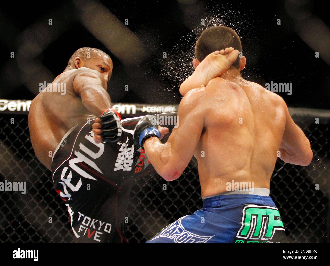 John Howard, left, lands a kick to the head of Jake Ellenberger, right ...