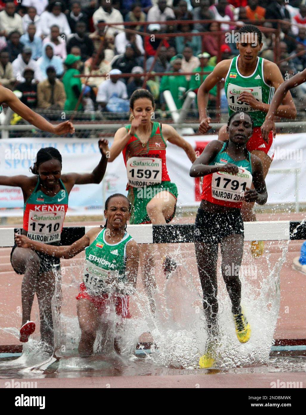 Athletes jump on the water hurdler in the 3000 meters women ...