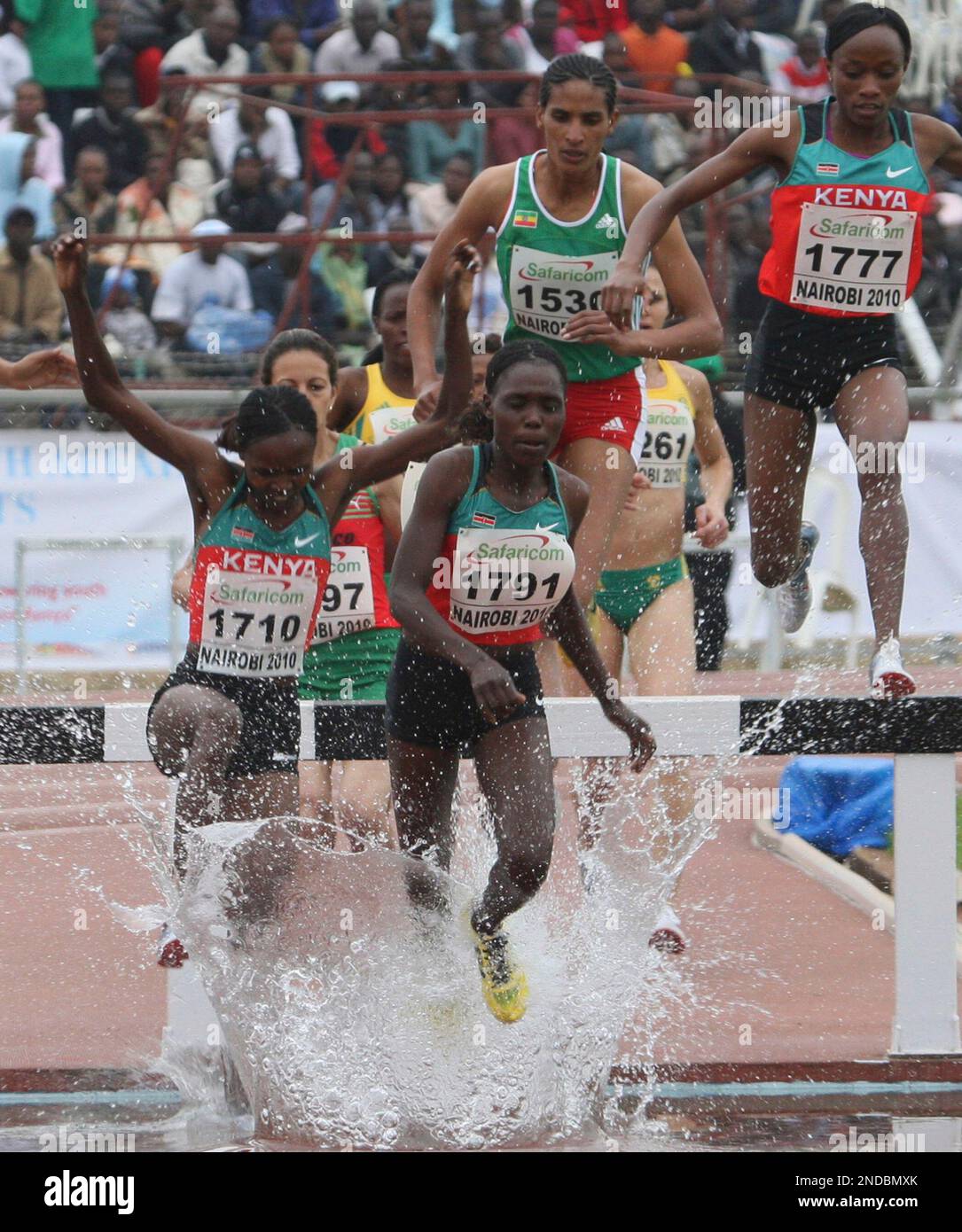 Athletes jump on the water hurdler in the 3000 meters women ...
