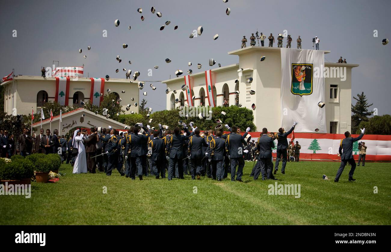 Lebanese officers throw their hats during a graduation ceremony marking ...