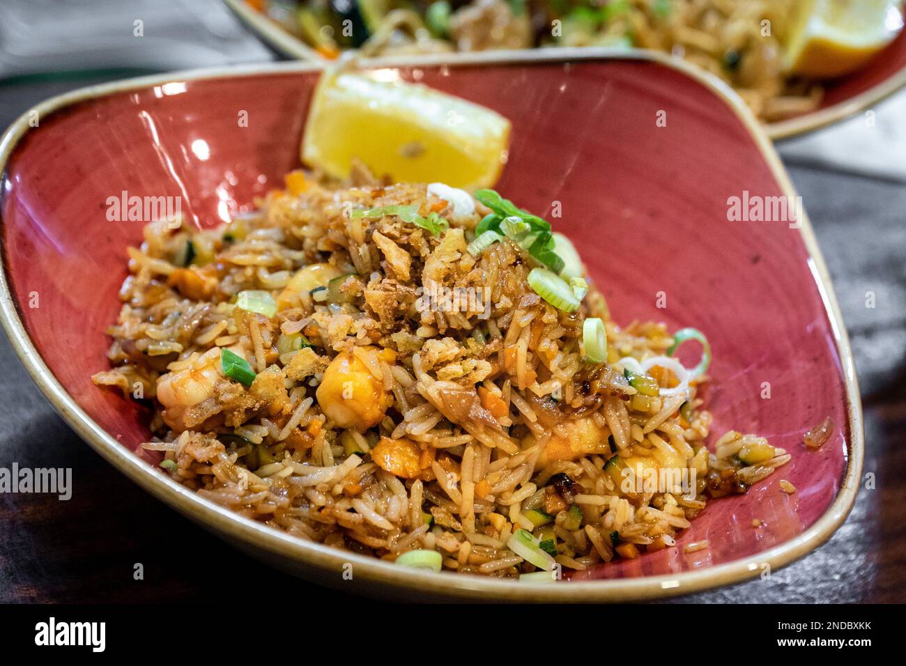 a tasty bowl of oriental style prawn fried rice served with a lemon ...