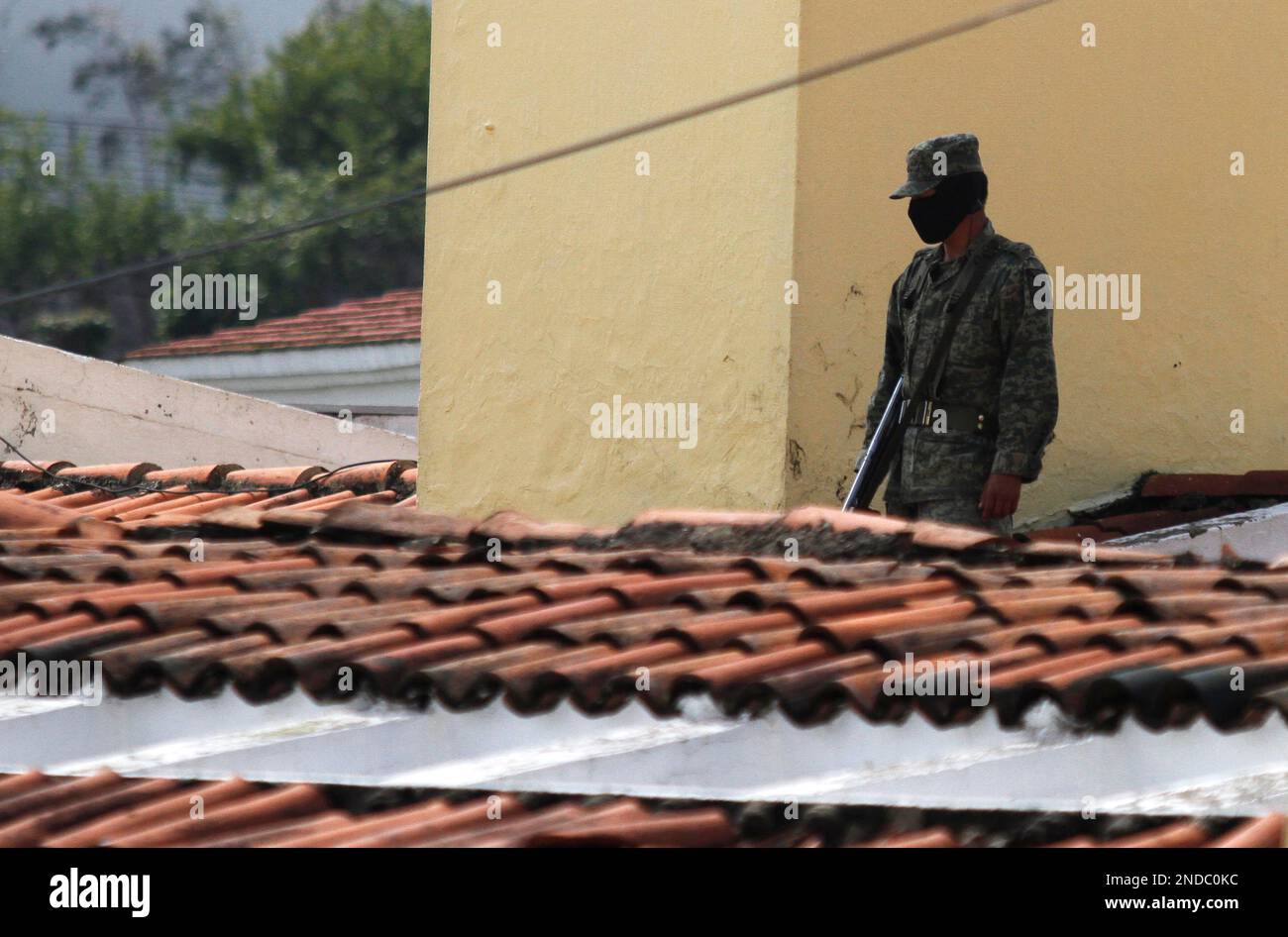 A soldier stands guard on the roof of the house where, according to ...